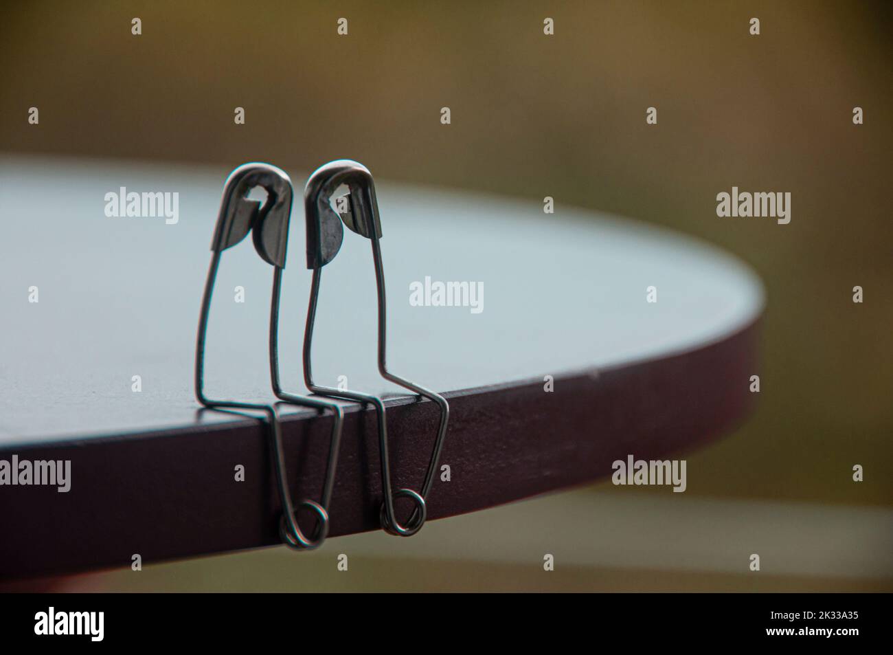 Safety pin couple sitting on table with customizable space for text and ...