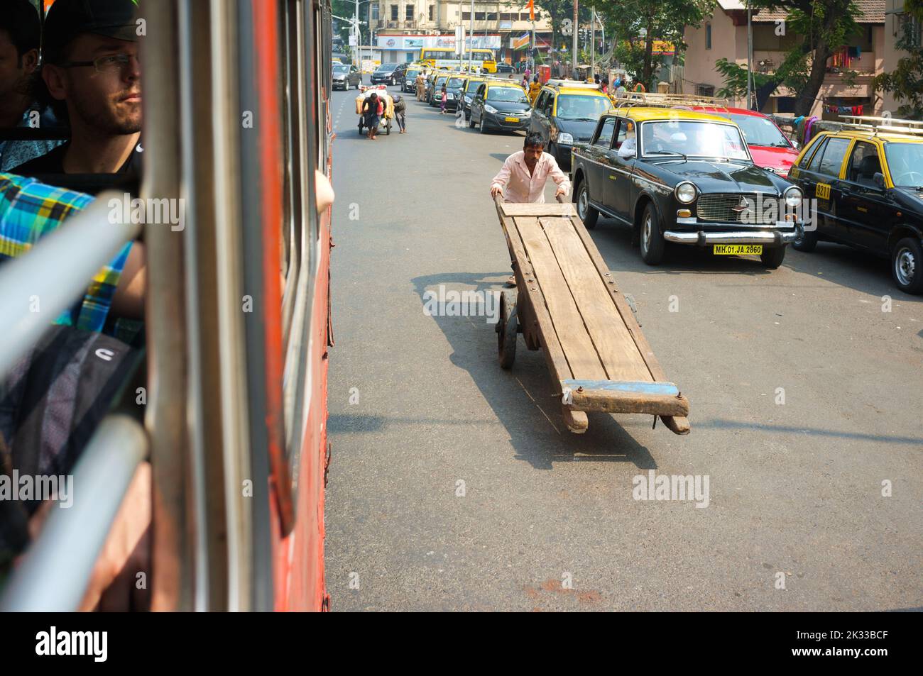 A view from the bus of an Indian man pushing a cart in the streets of ...