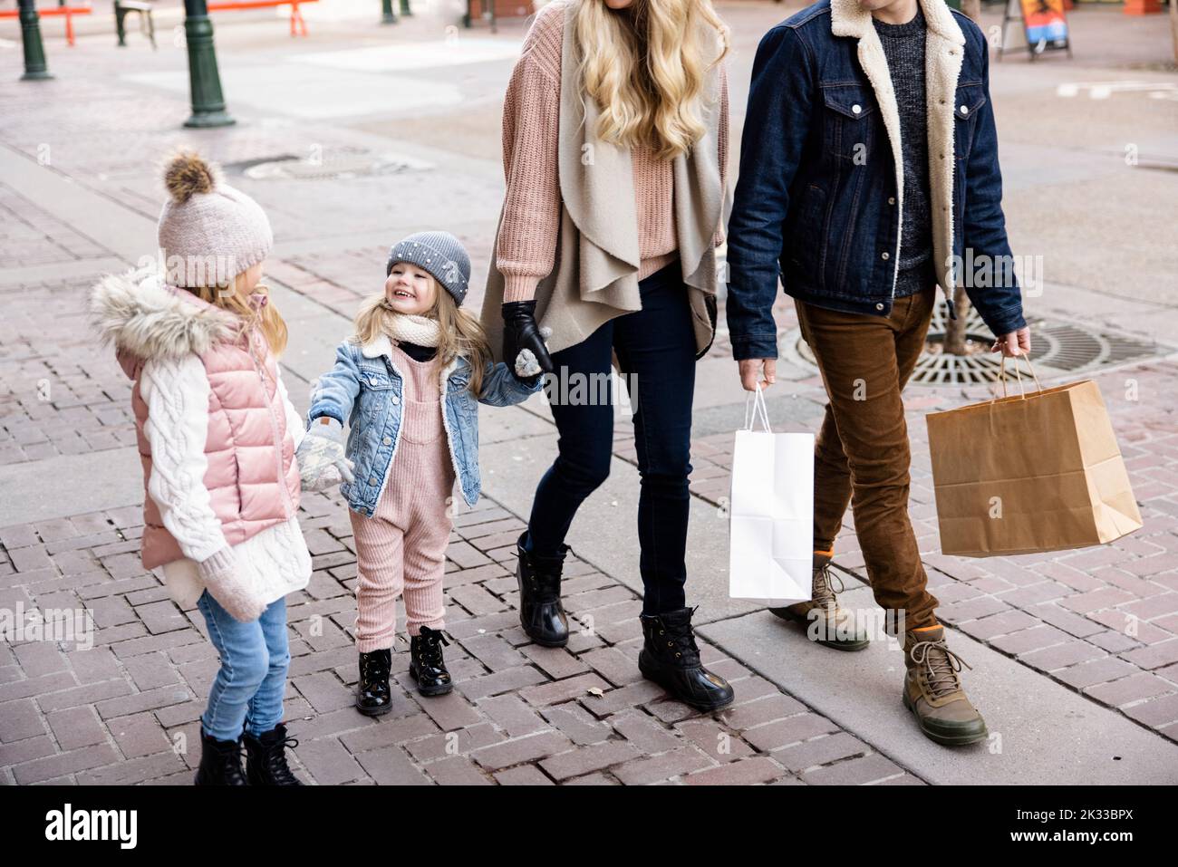 Happy family in winter clothes shopping on urban sidewalk Stock Photo ...