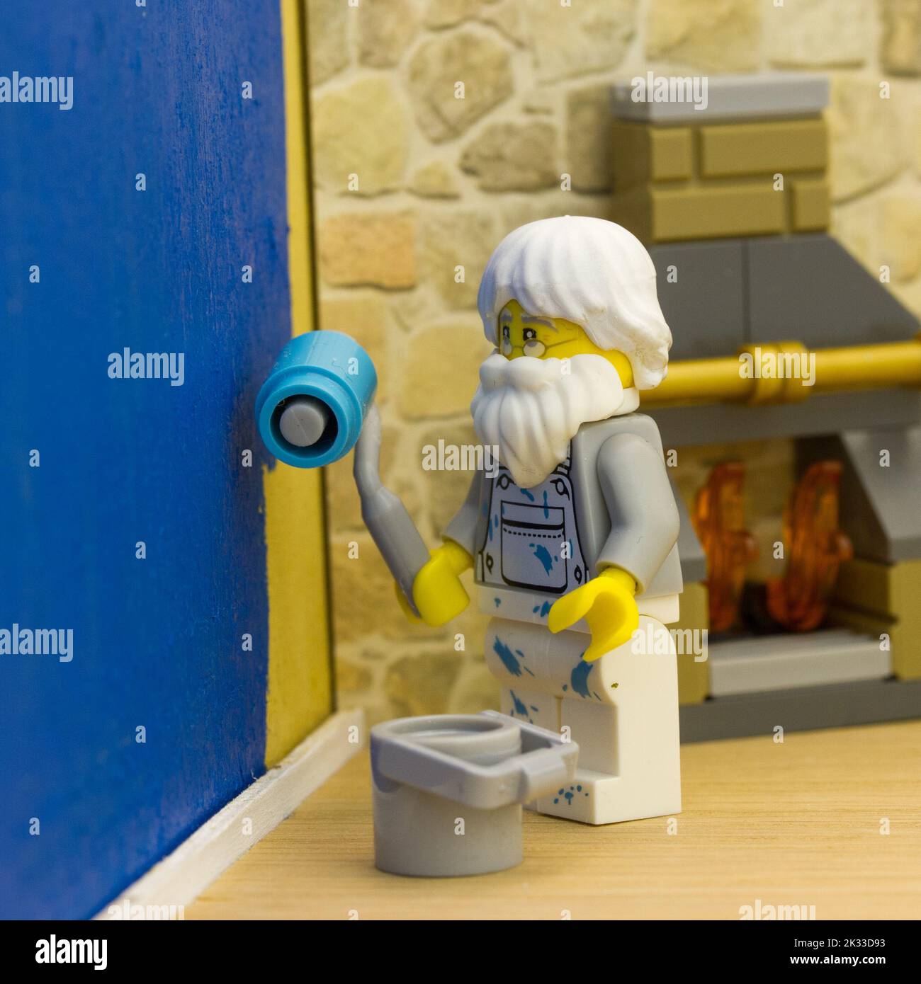 A lego figurine of an old man decorating the wall with blue paint Stock ...