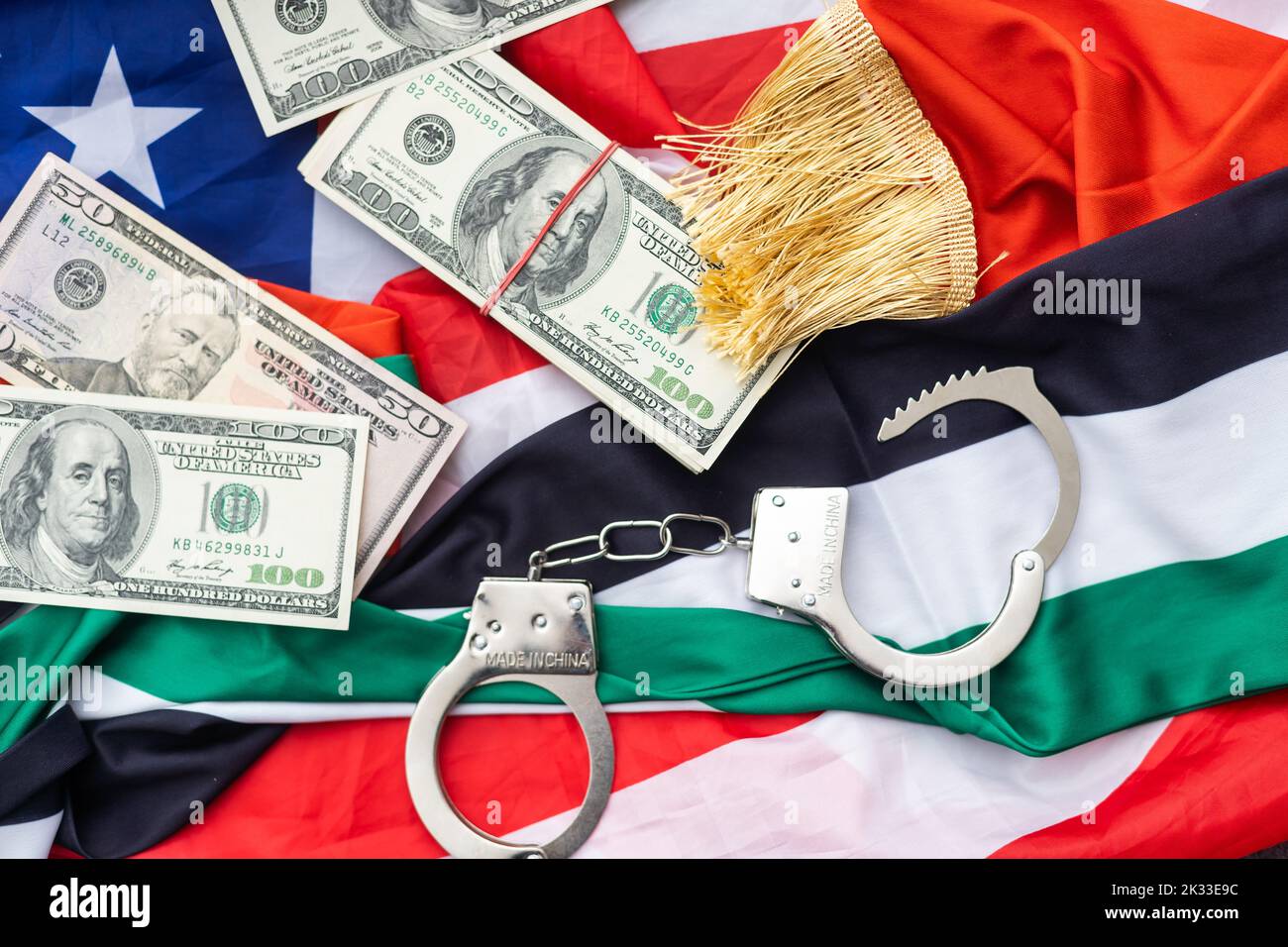 metal handcuff, american dollars cash over flag of USA and UAE flags ...