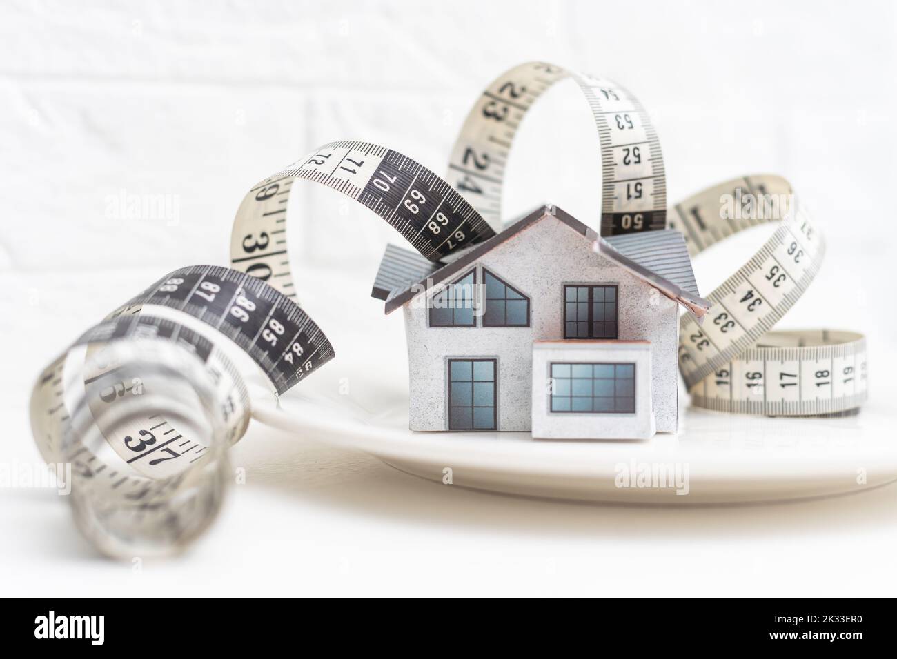 measuring tape and toy house in a white plate Stock Photo - Alamy