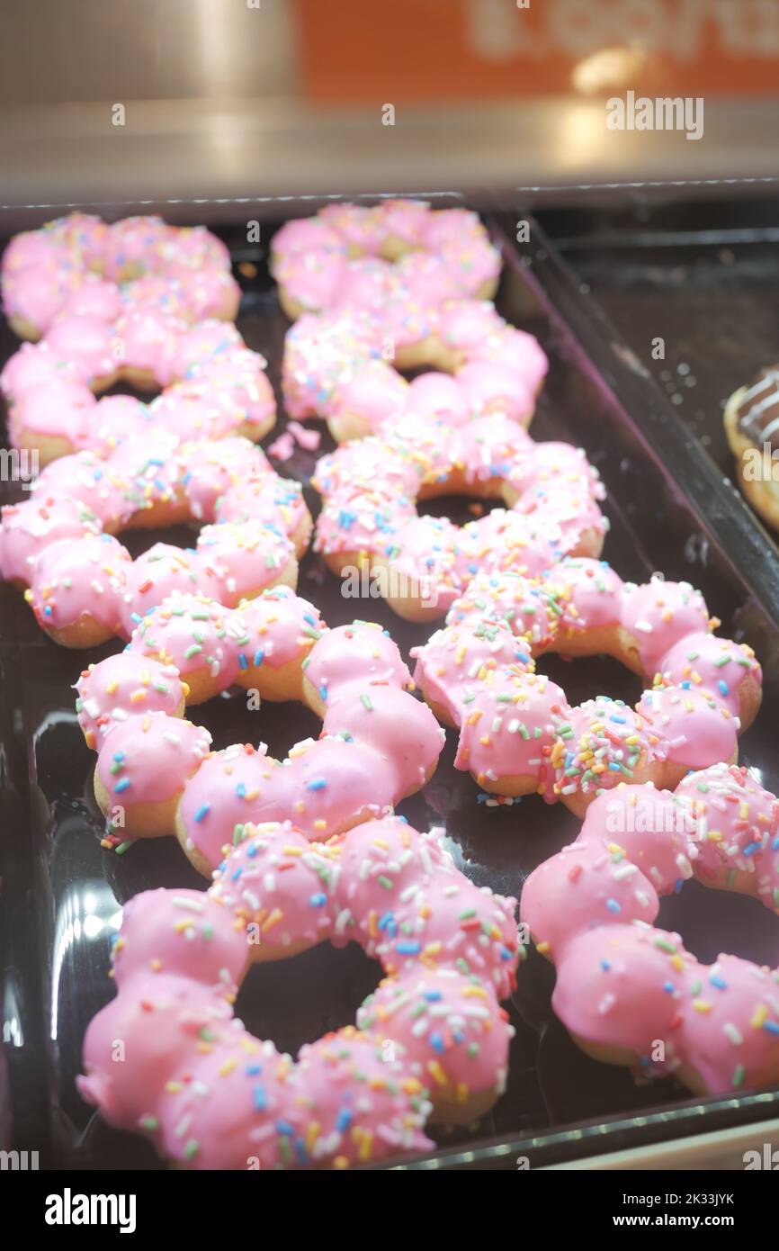 pink color chocolate donuts display for sale at local store Stock Photo ...