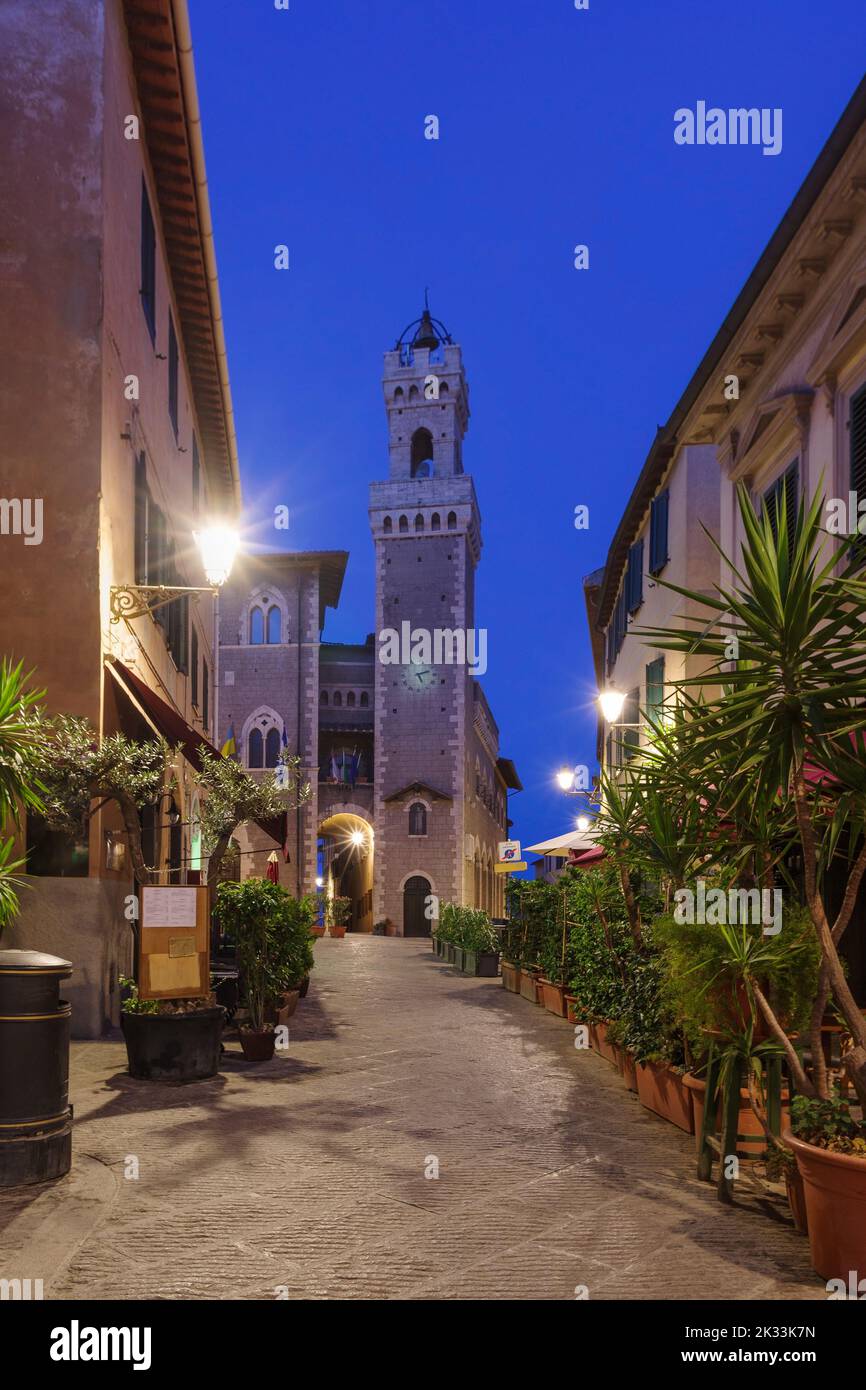 Night scene along typical Italian narrow street of Piombino old town ...