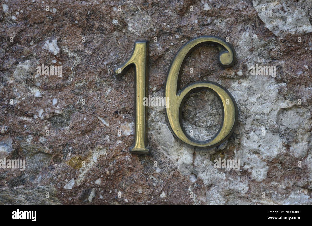 Antique brass street number on a handcrafted stone wall Stock Photo - Alamy