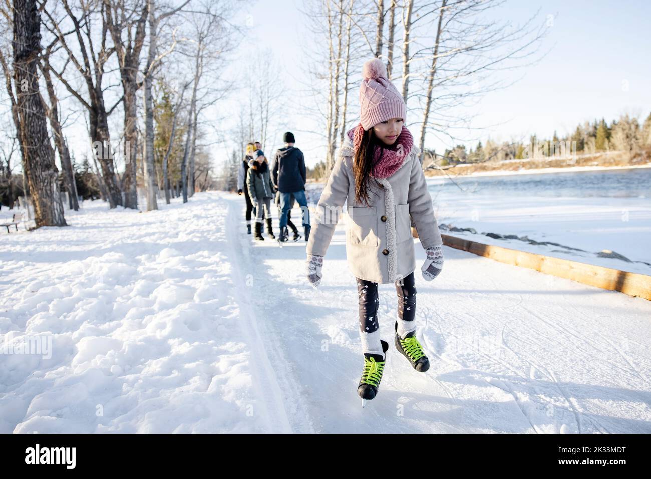 Family ice skating on path in snowy winter park Stock Photo - Alamy