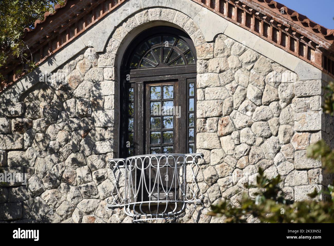 Arched wooden window on a handcrafted stone wall of the Pantelis ...