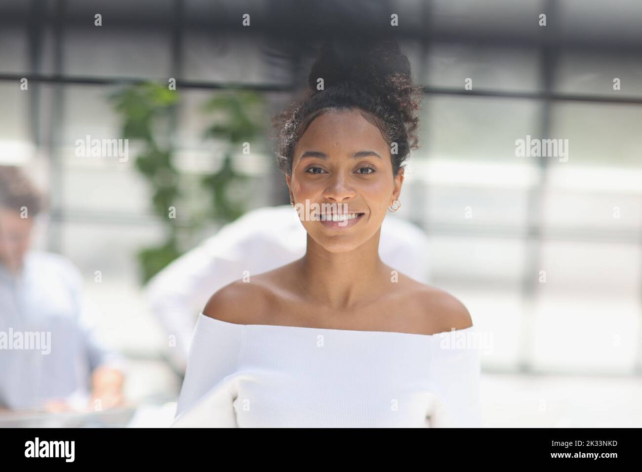 a business woman smiling inside office building Stock Photo - Alamy