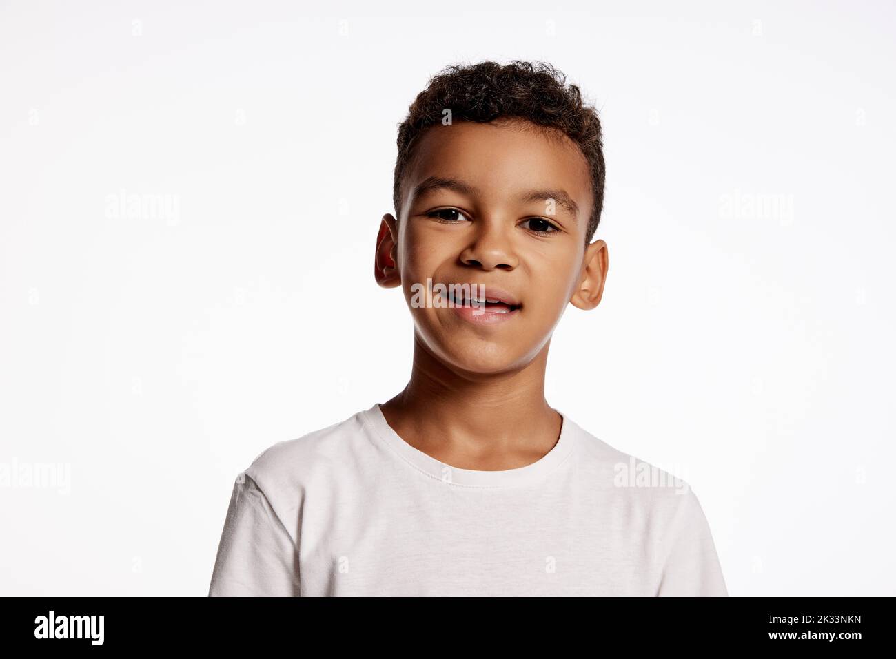 Smirk. Half-length portrait of african little boy in white tee ...