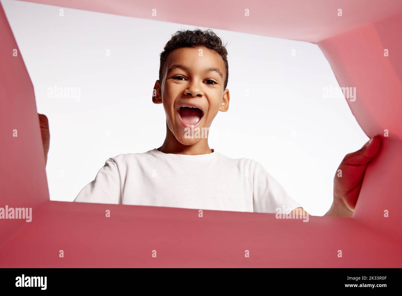 Happy smiling kid, little boy looking inside box during opening ...