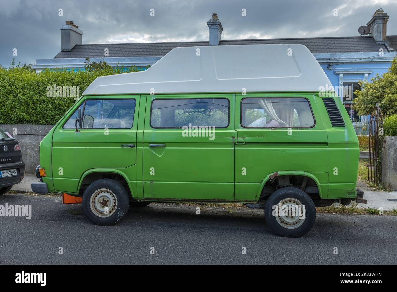 A classic VW campervan in green color Stock Photo - Alamy