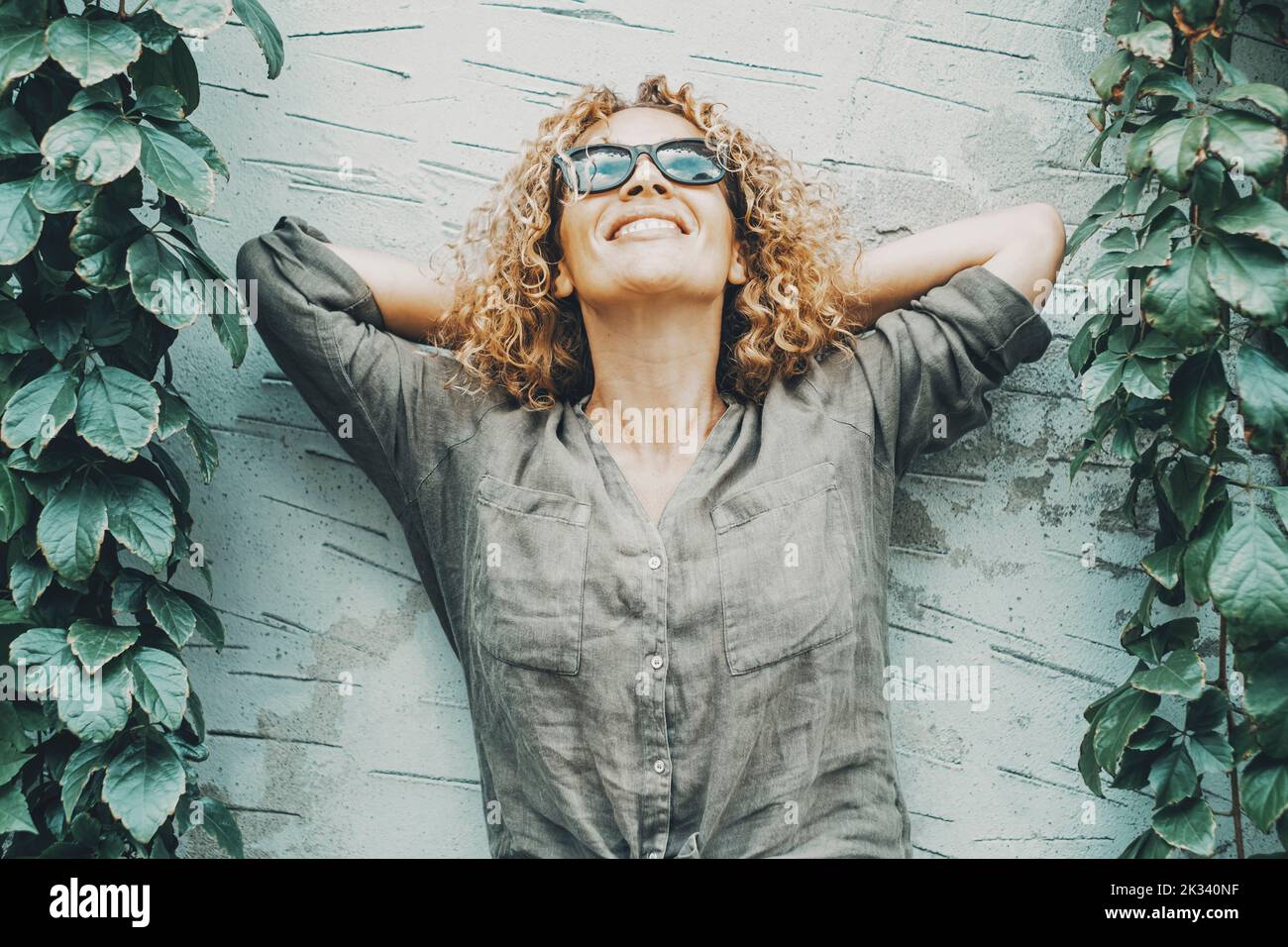 Happy and satisfied woman smiling and looking in the air with green ...