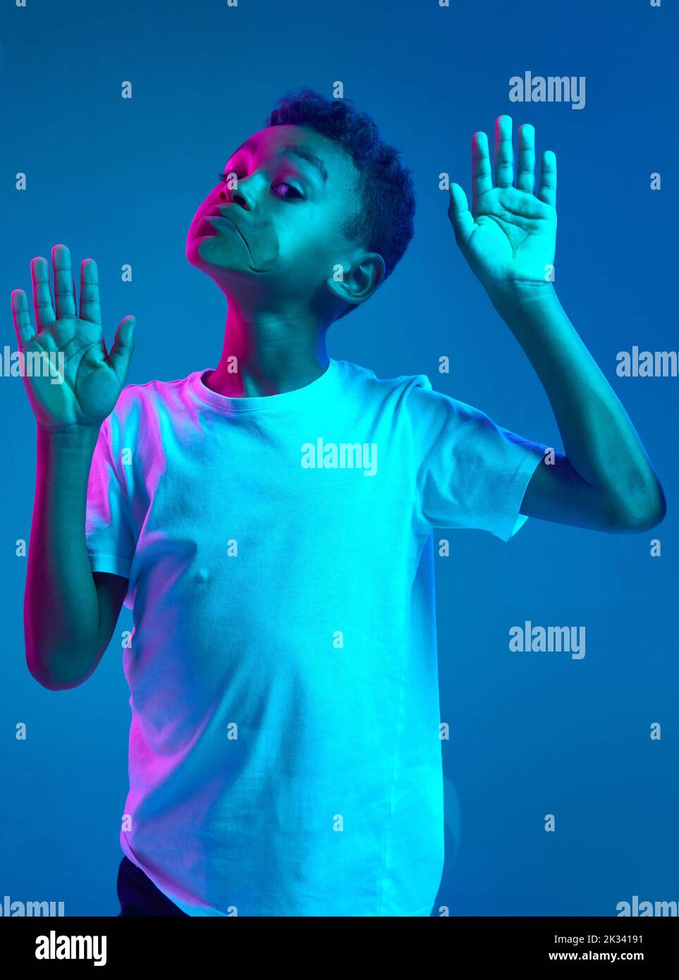 Close-up of little boy leaning against transparent glass by cheek ...