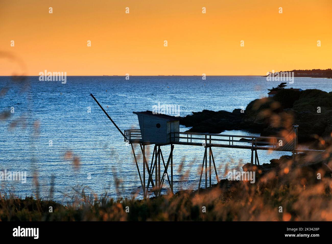 View through grasses to the Atlantic Ocean, traditional fisherman's hut ...