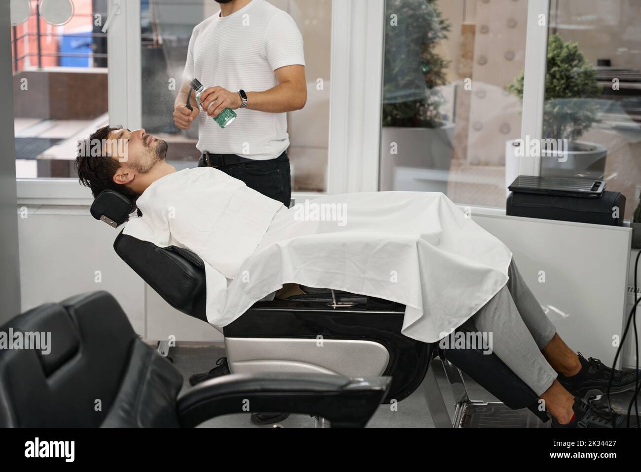 Hair salon worker with perfume bottle standing by the client Stock ...