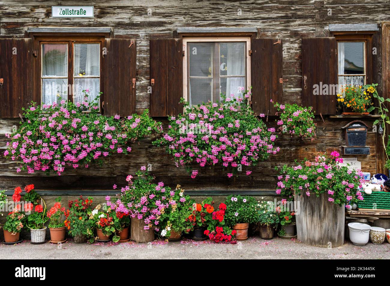 Window with geraniums on an old wooden house in Zollstrasse, Oberstdorf ...