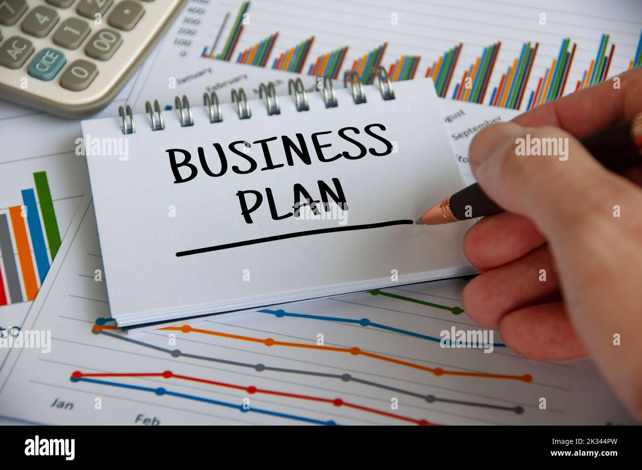 Business plan written on notepad with graph analysis background. Business plan concept Stock ...