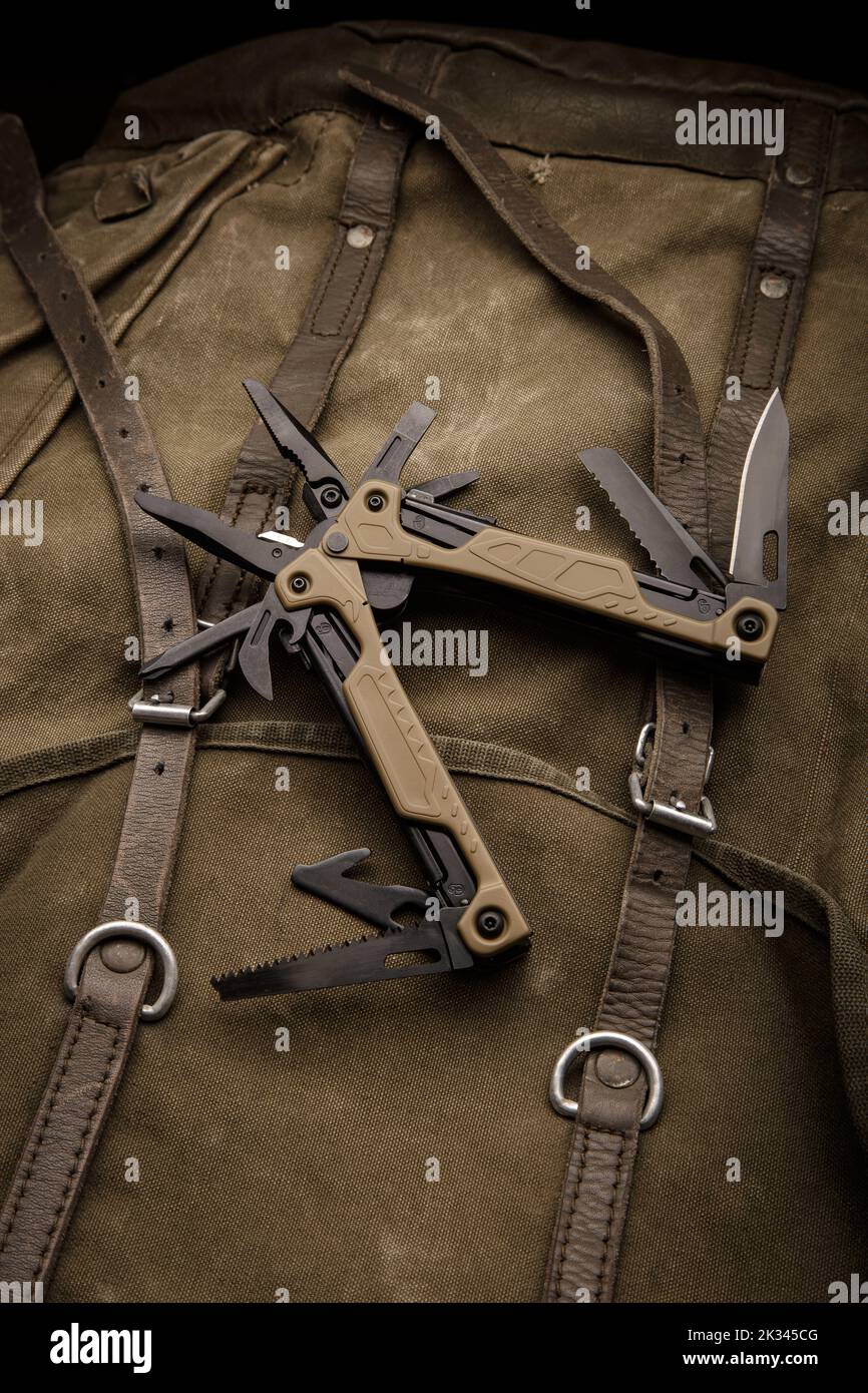 Modern multitool with many tools. A portable multitasking tool on a ...