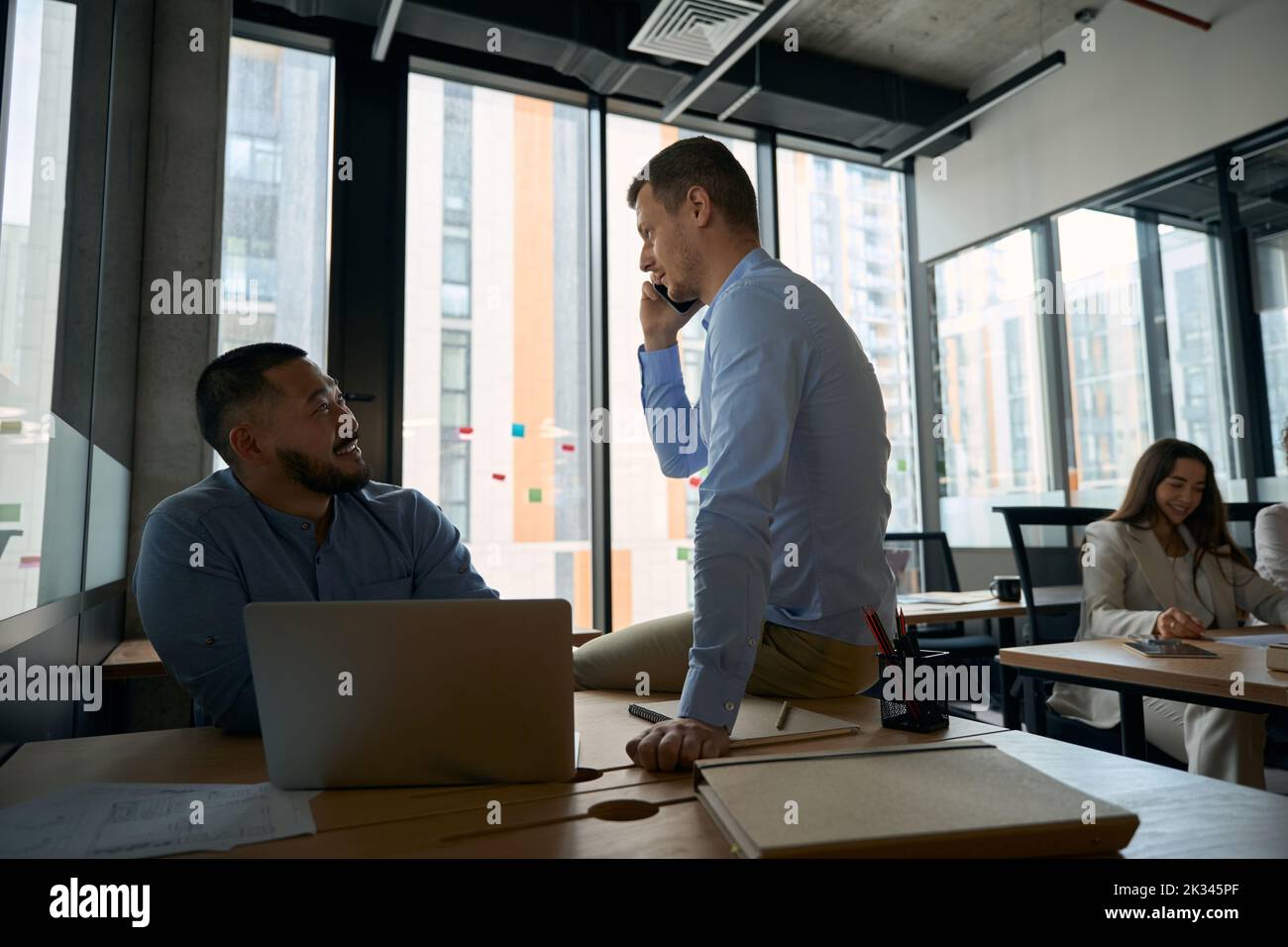Smiling office worker and his coworker in workplace Stock Photo - Alamy