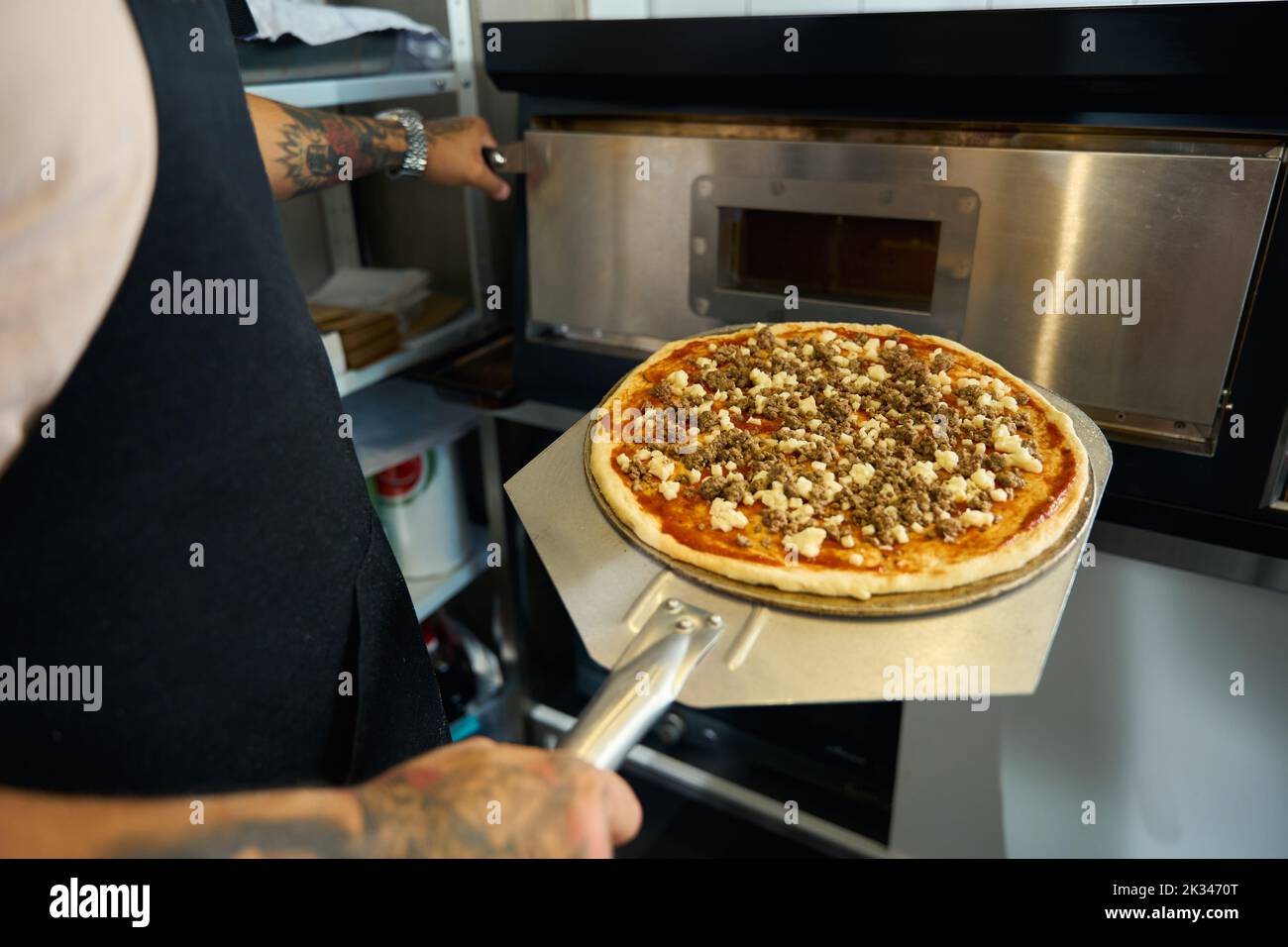 Cropped photo of chef holding a delicious pizza near oven Stock Photo ...