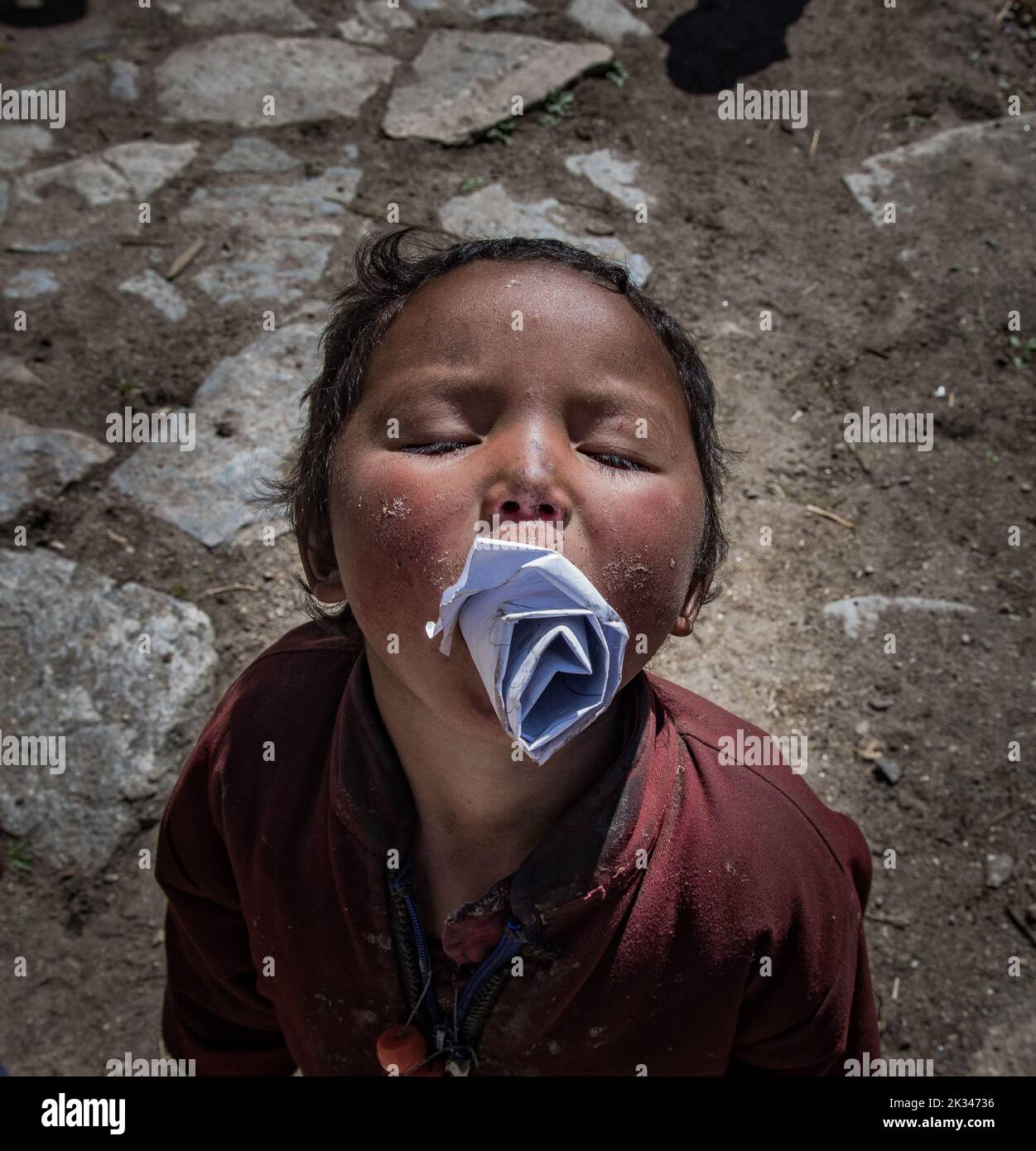 A child pretending to eat a piece of paper. "Eating his words Stock ...