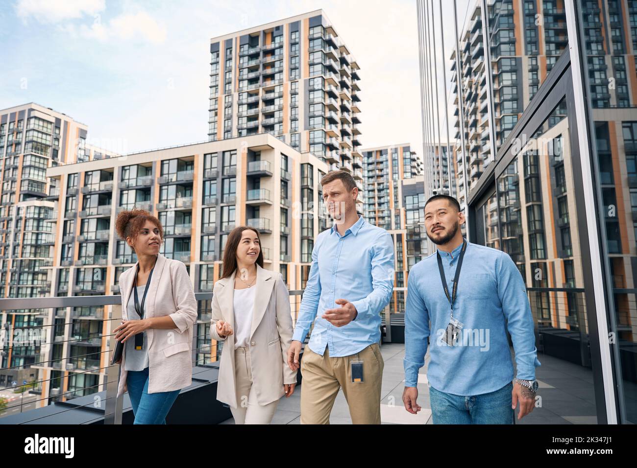 Group of corporate workers walking on office balcony Stock Photo - Alamy