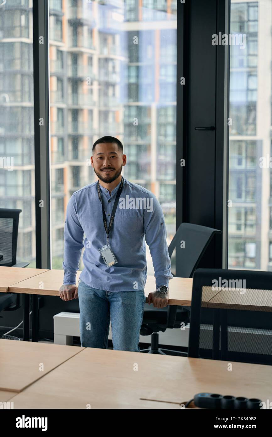 Happy corporate manager posing for camera in workplace Stock Photo - Alamy