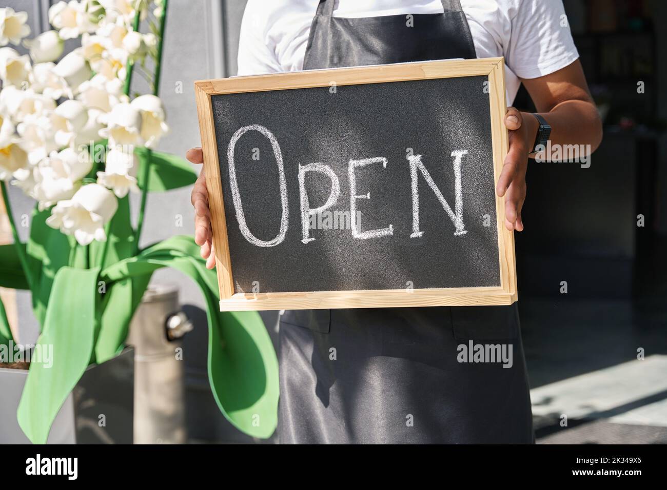 Signboard open in the hands of a multiracial person Stock Photo - Alamy