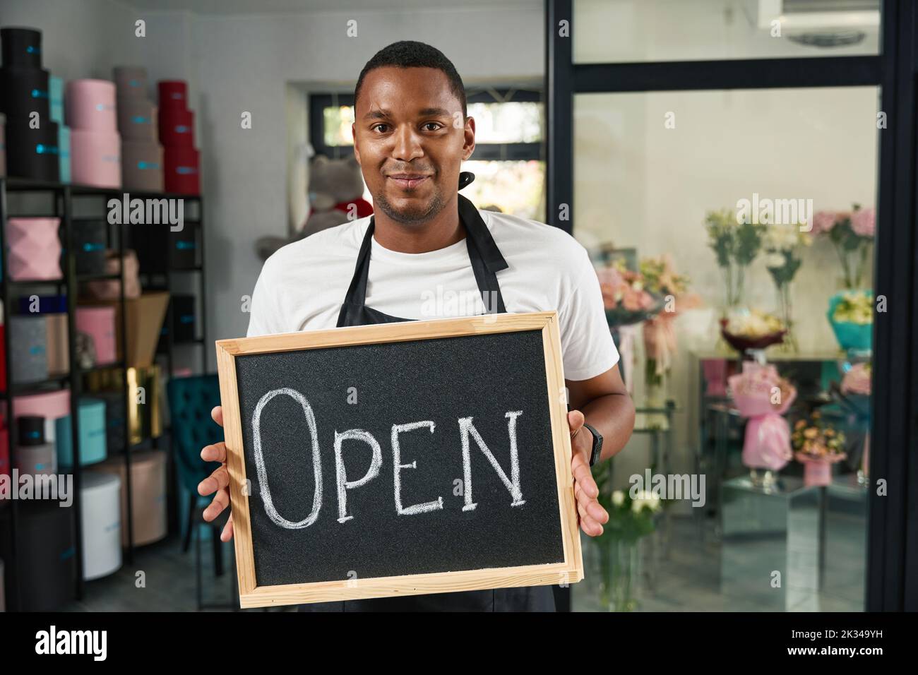 Florist shop with a signboard in his hands Stock Photo - Alamy