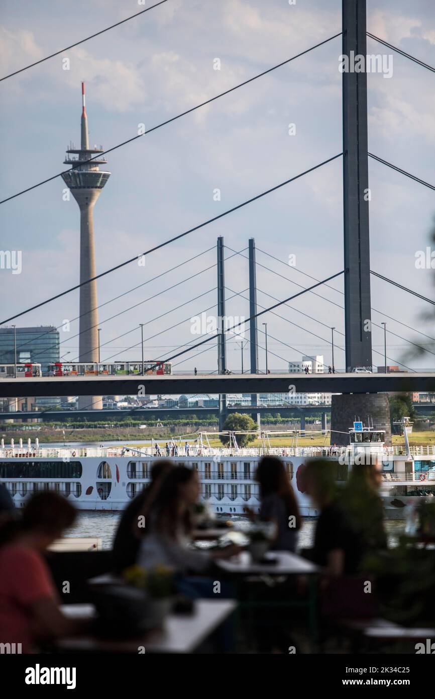 Summer evening in Duesseldorf on the Rhine. Visitors in the beer garden ...