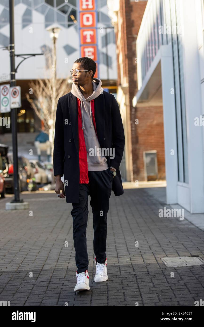 Stylish cool young man walking on city sidewalk Stock Photo - Alamy