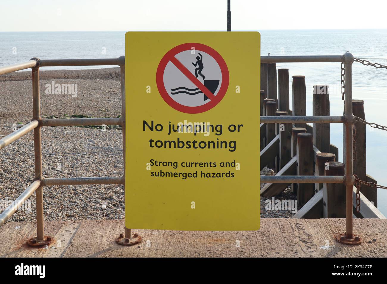 A yellow sign by the sea prohibiting jumping or tombstoning due to ...