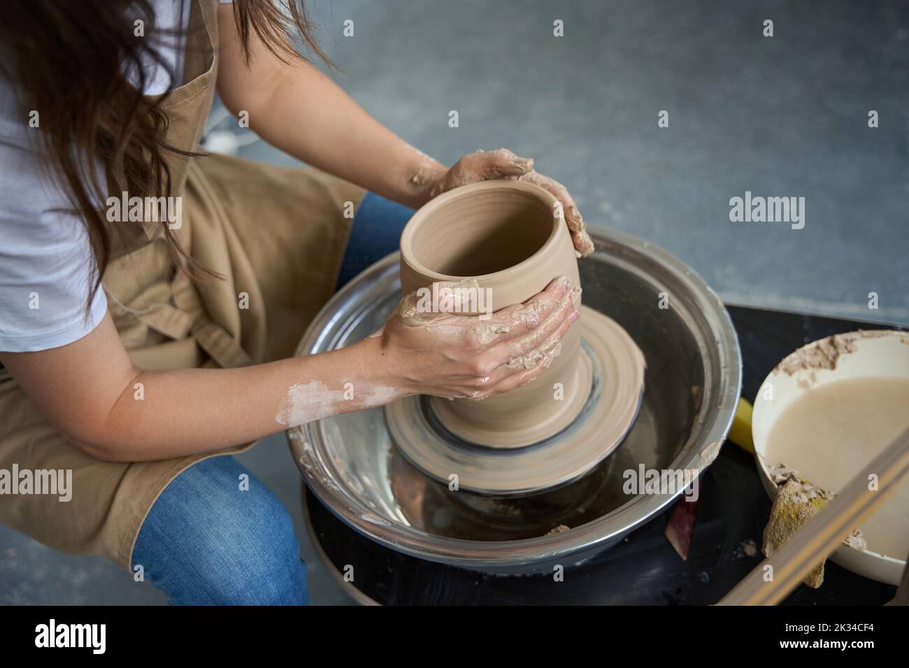 Craftswoman forms a clay pot on a potter wheel Stock Photo - Alamy
