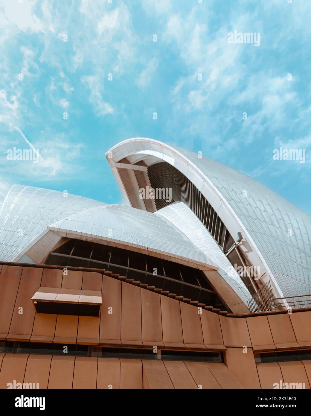 A vertical low angle shot of the Sydney Opera House under a blue sky ...