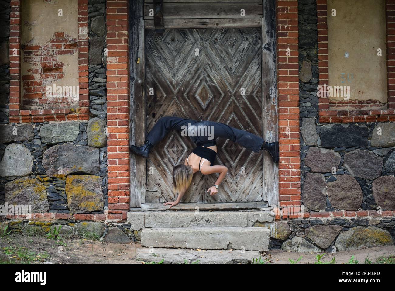 A young girl, a dancer of sports dance and acrobatics, does an exercise ...