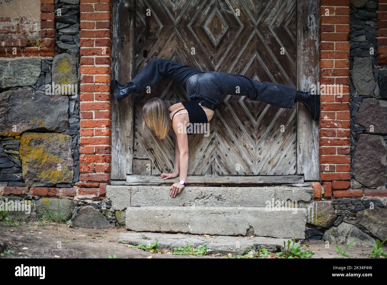 A young girl, a dancer of sports dance and acrobatics, does an exercise ...
