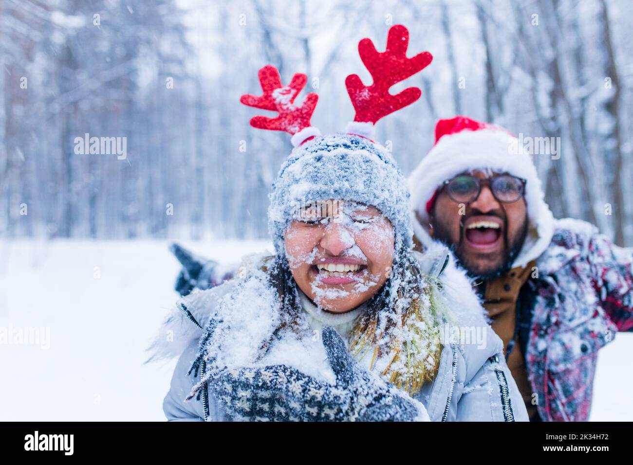 portrain of indian man and woman in red santa hat and deer horns with ...