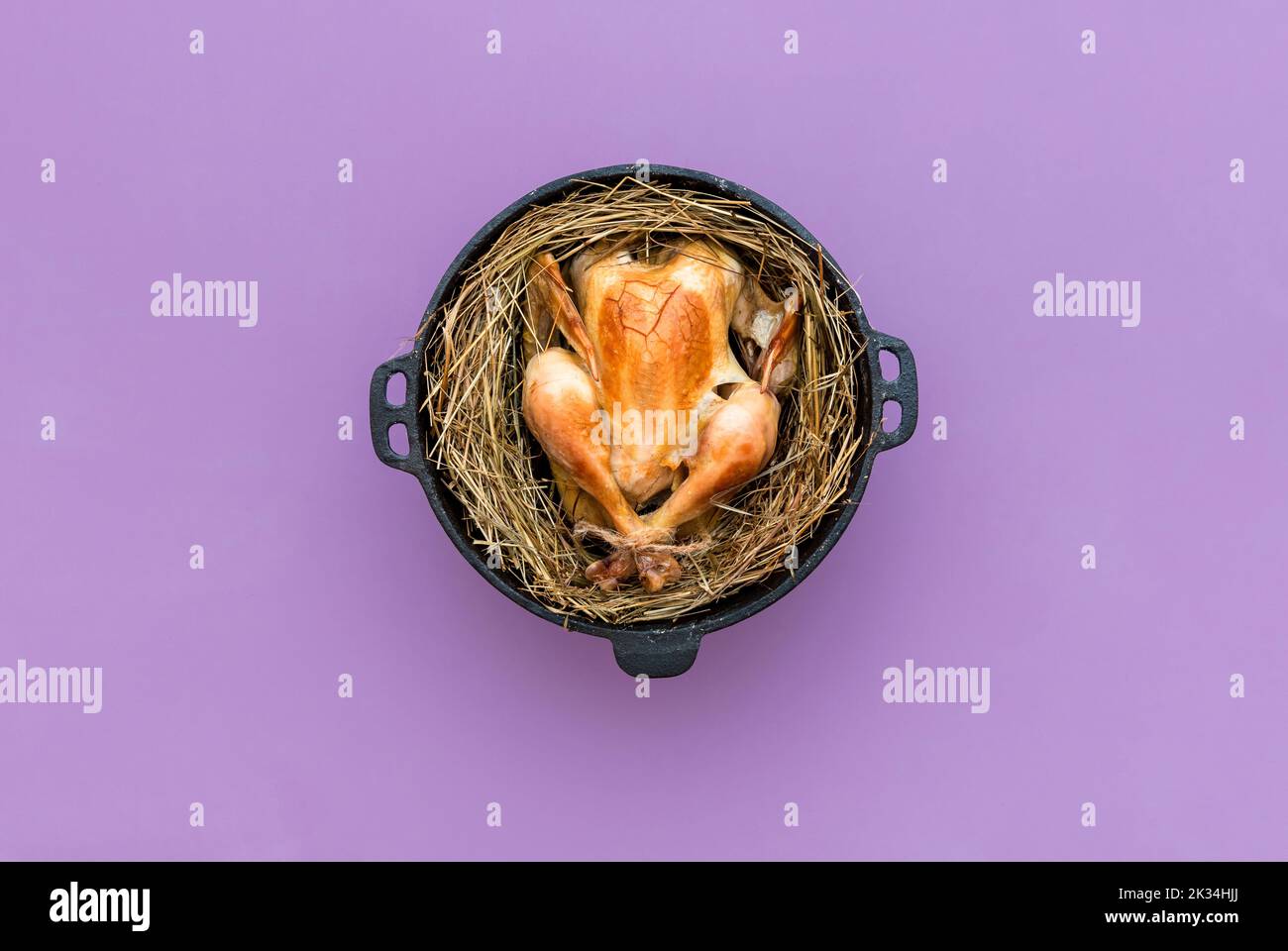 Above view with a whole chicken baked in a rustic method, on a layer of ...