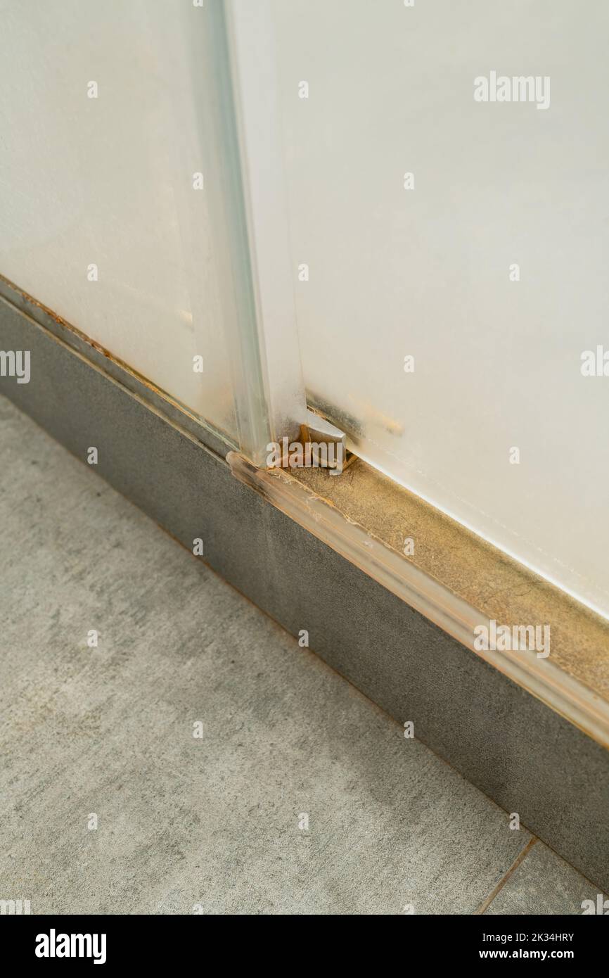A close-up of the mechanism and joints of a shower stall screen with ...