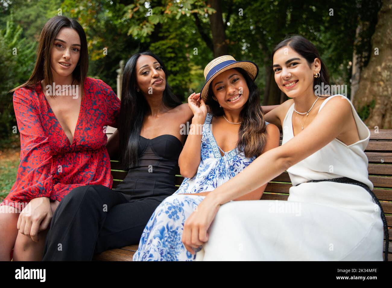 Group Of Multiracial Friends Outdoor Having Fun Seated On A Bench At
