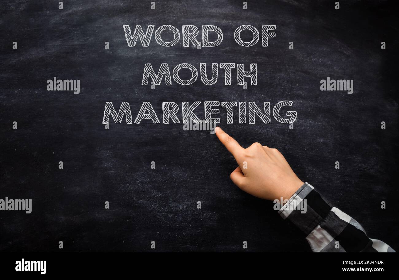 Man point to test Word of Mouth Marketing on chalkboard Stock Photo - Alamy