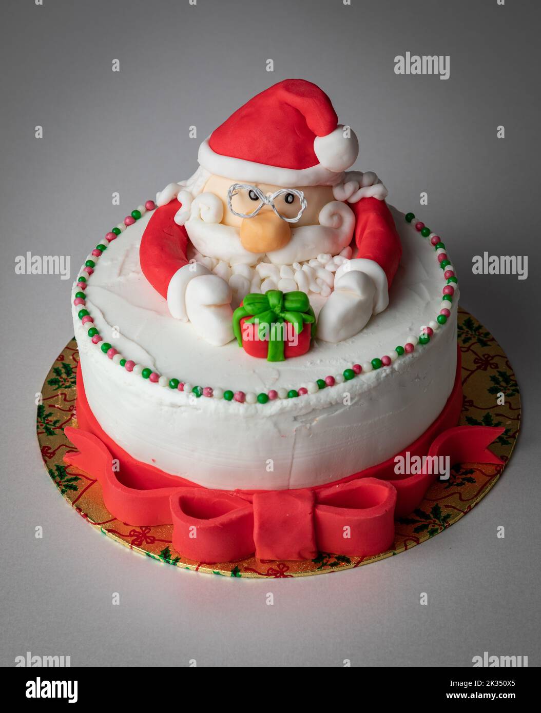 A top view of a cake decorated with the face of Santa clause in front ...