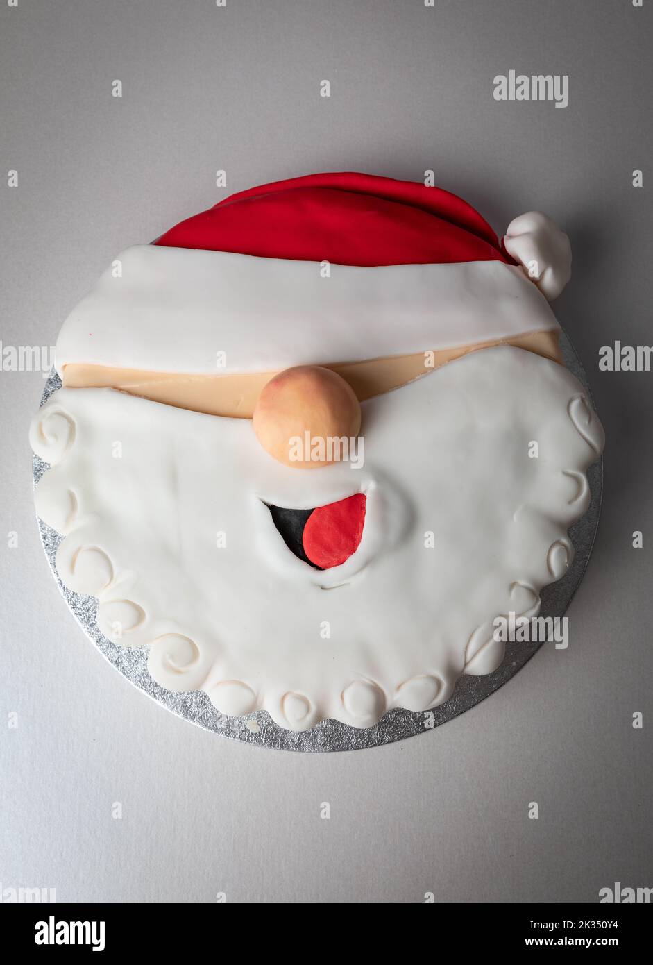A top view of a cake decorated with the face of Santa clause in front ...