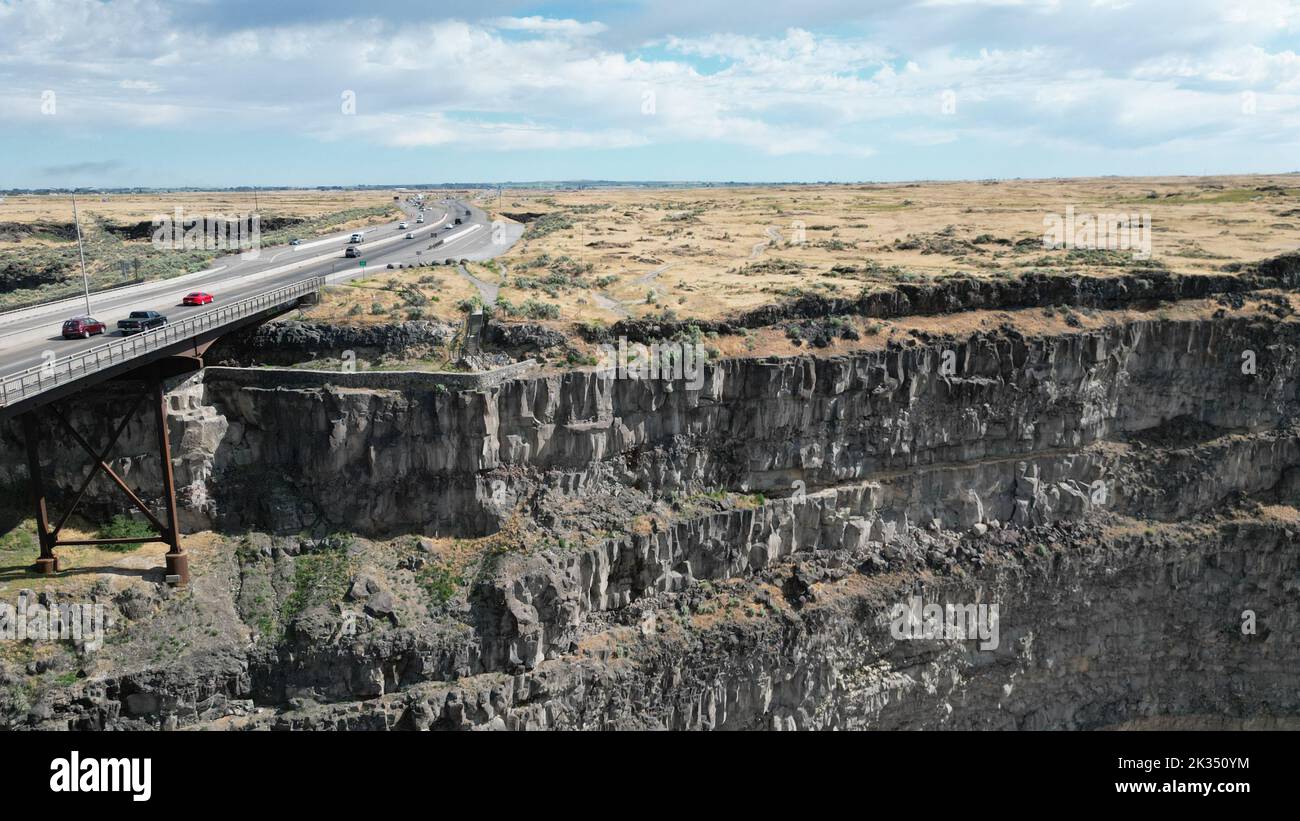 A bird's eye view of a bridge going over a steep cliff with an open ...