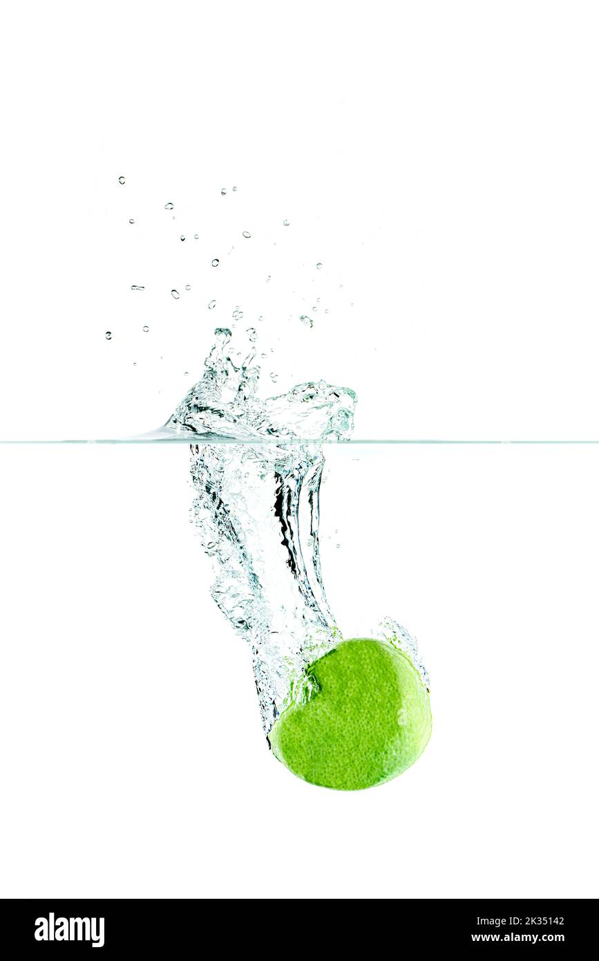 A Green apple falling into water splash in a white background Stock ...