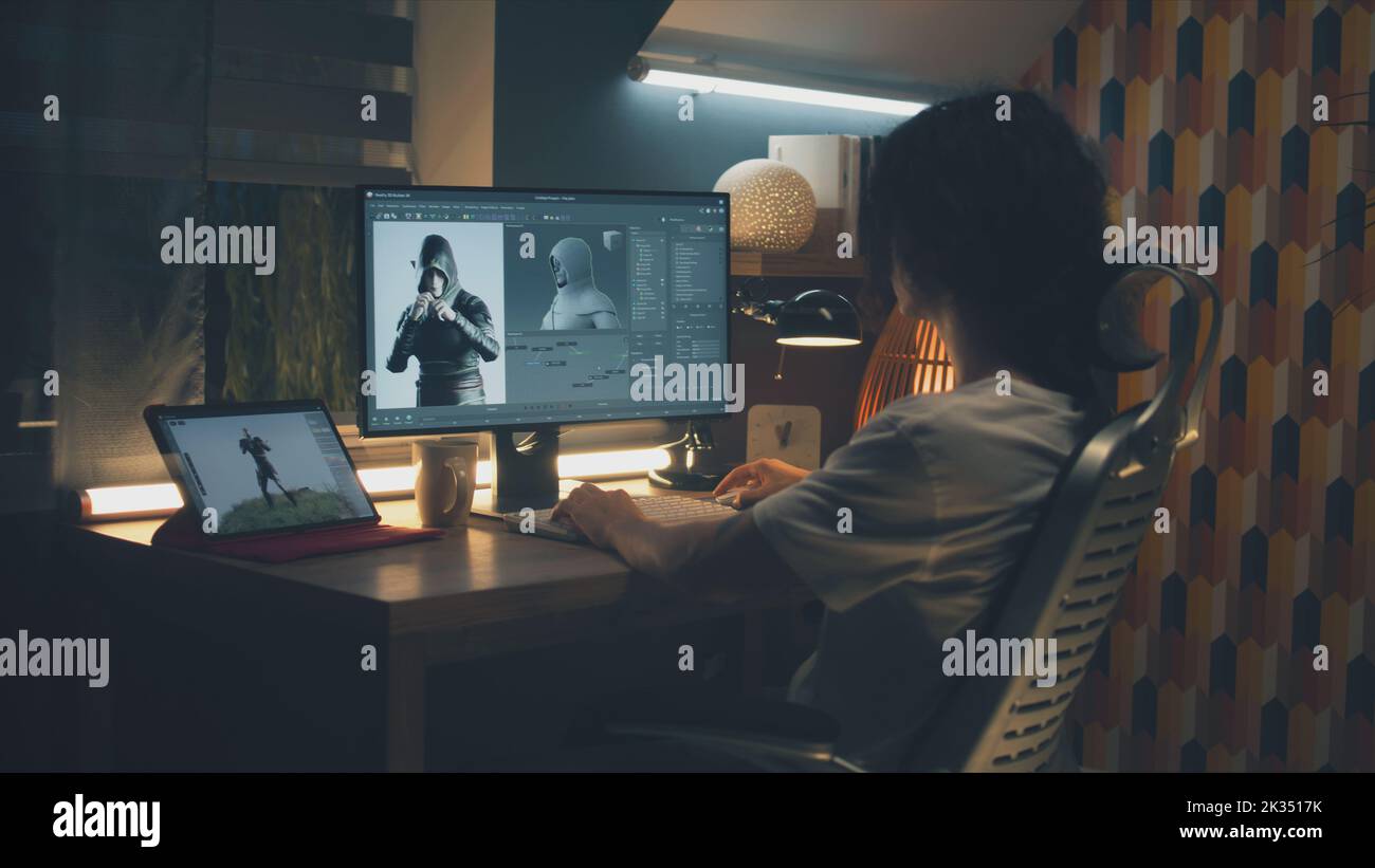 Male 3D designer sitting at the table at home and making animation for ...