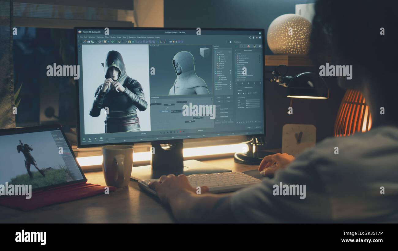 Male 3D designer sitting at the table at home and making animation for ...