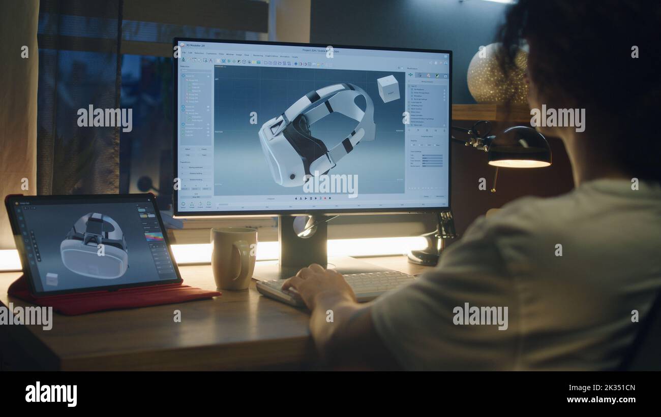 Male young freelancer working from home and creating 3D prototype of modern VR goggles in ...