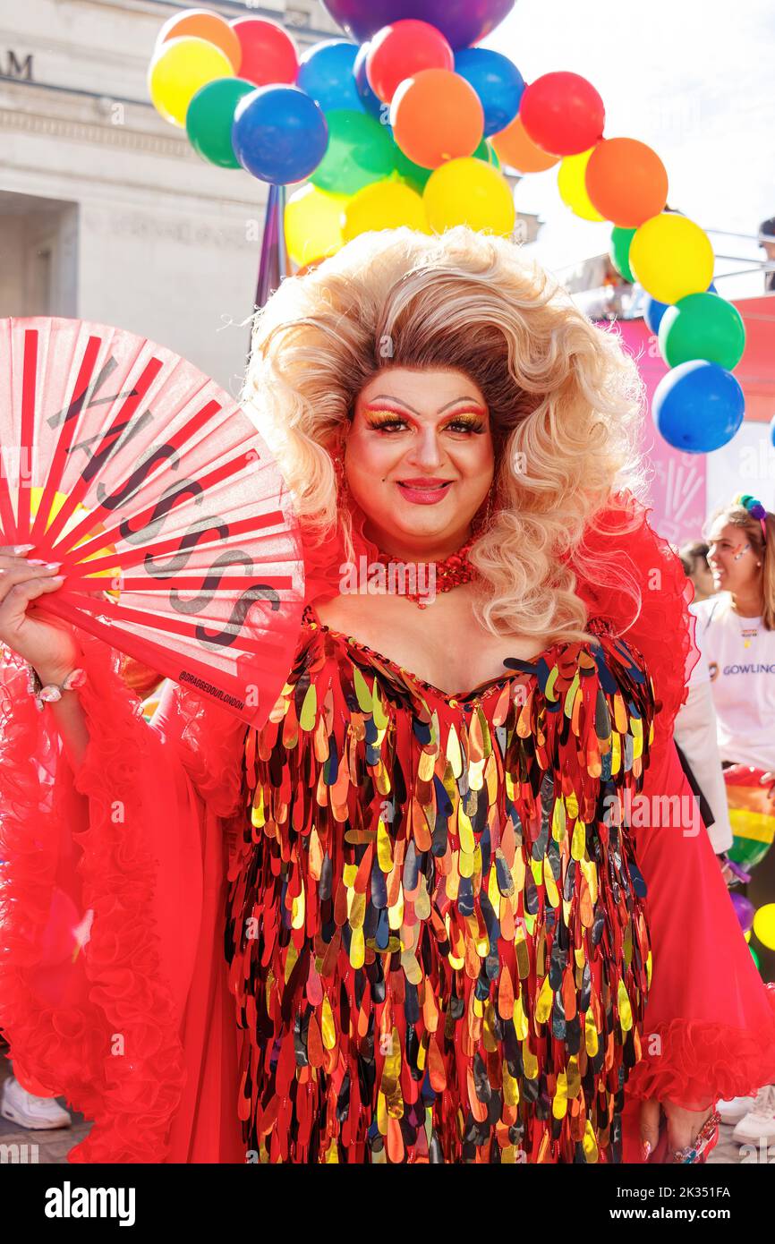 blonde trans woman in drag wearing red sparkly dress with fan at Gay ...