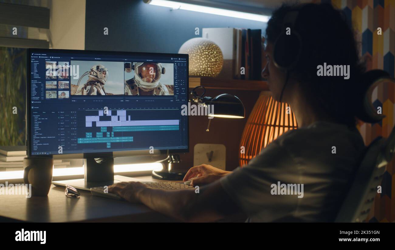 Guy in headphones editing video with astronauts for space blog in ...